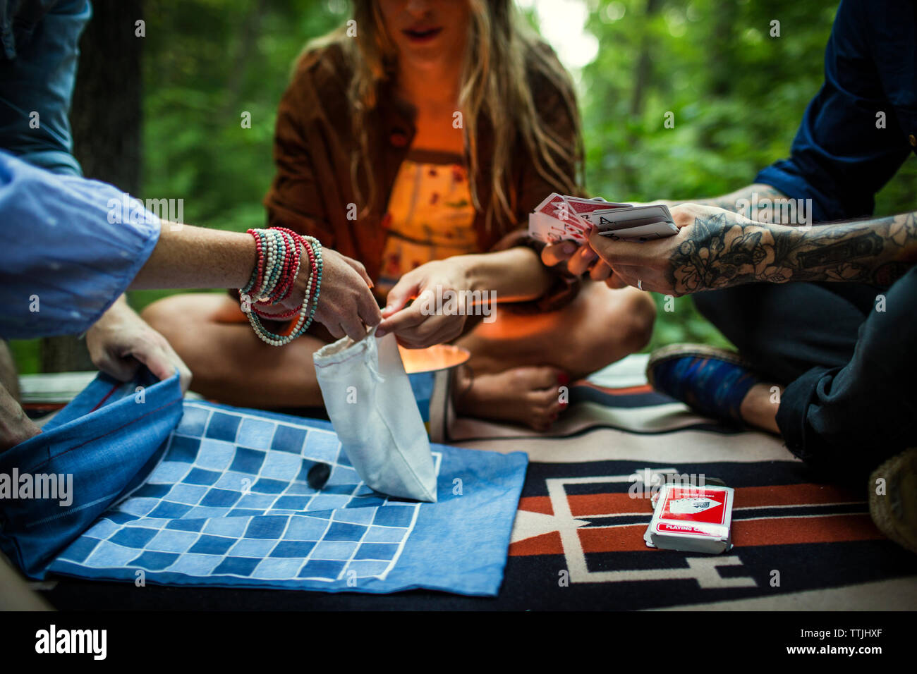 Friends playing card game while sitting on porch Stock Photo - Alamy