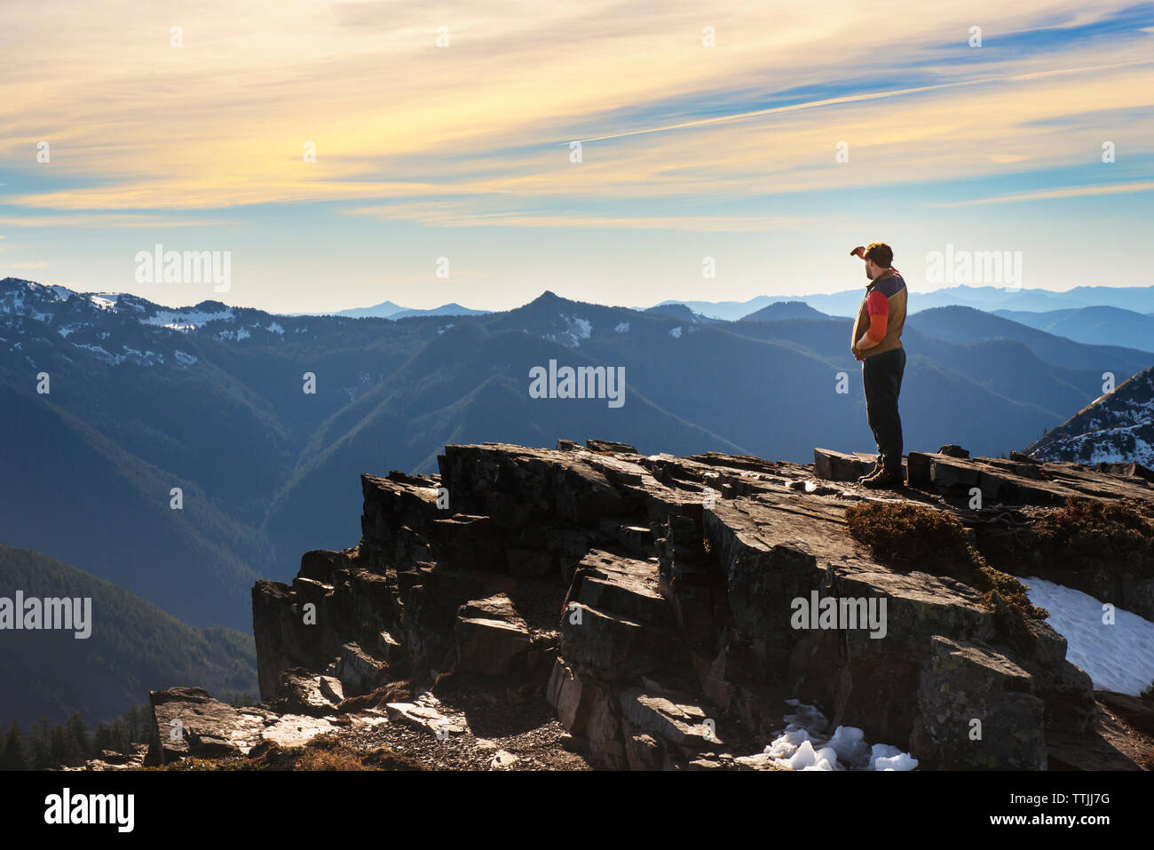 Side view of man standing on mountain at sunset Stock Photo - Alamy