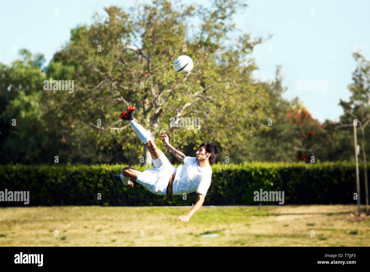 Young man kicking ball playing hi-res stock photography and images - Alamy