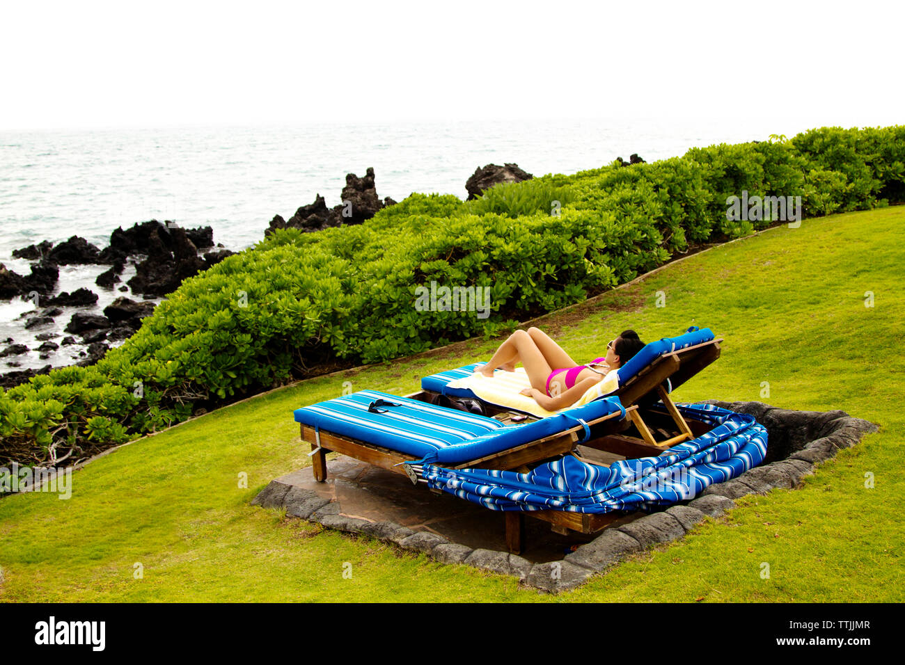 Woman relaxing on lounge chair at tourist resort Stock Photo - Alamy