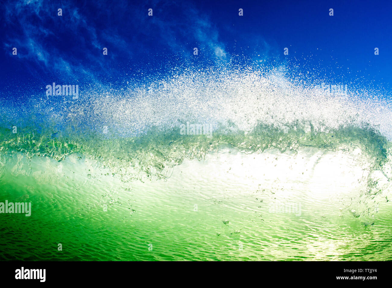 Close-up of wave splashing in sea against blue sky Stock Photo - Alamy