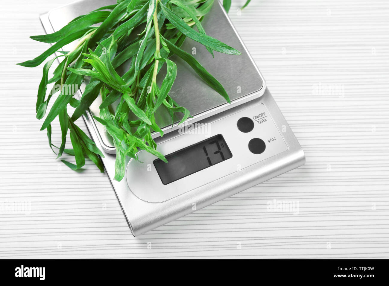 Herbs with digital kitchen scales on wooden background Stock Photo - Alamy