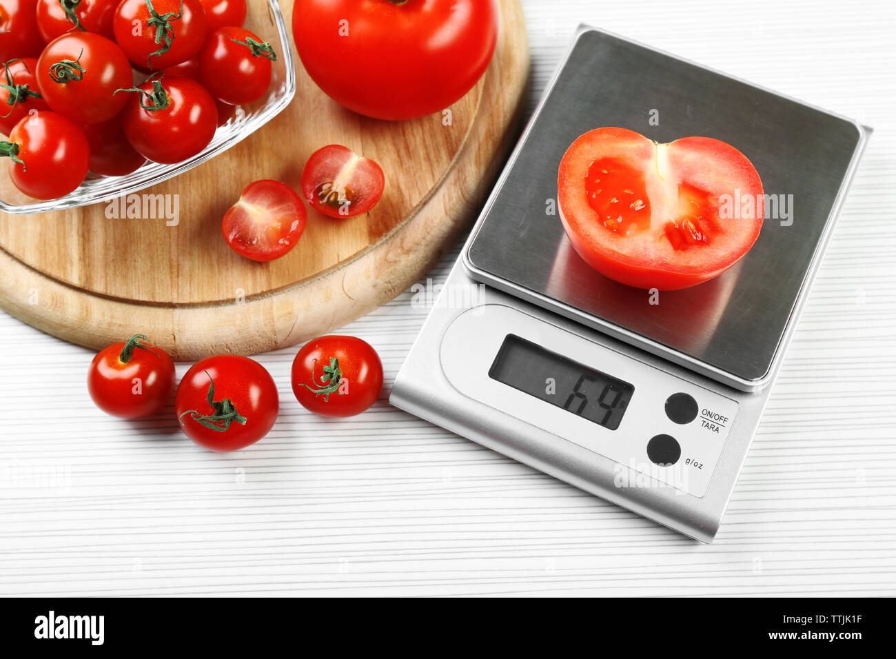 Tomatoes with digital kitchen scales on wooden background Stock Photo ...