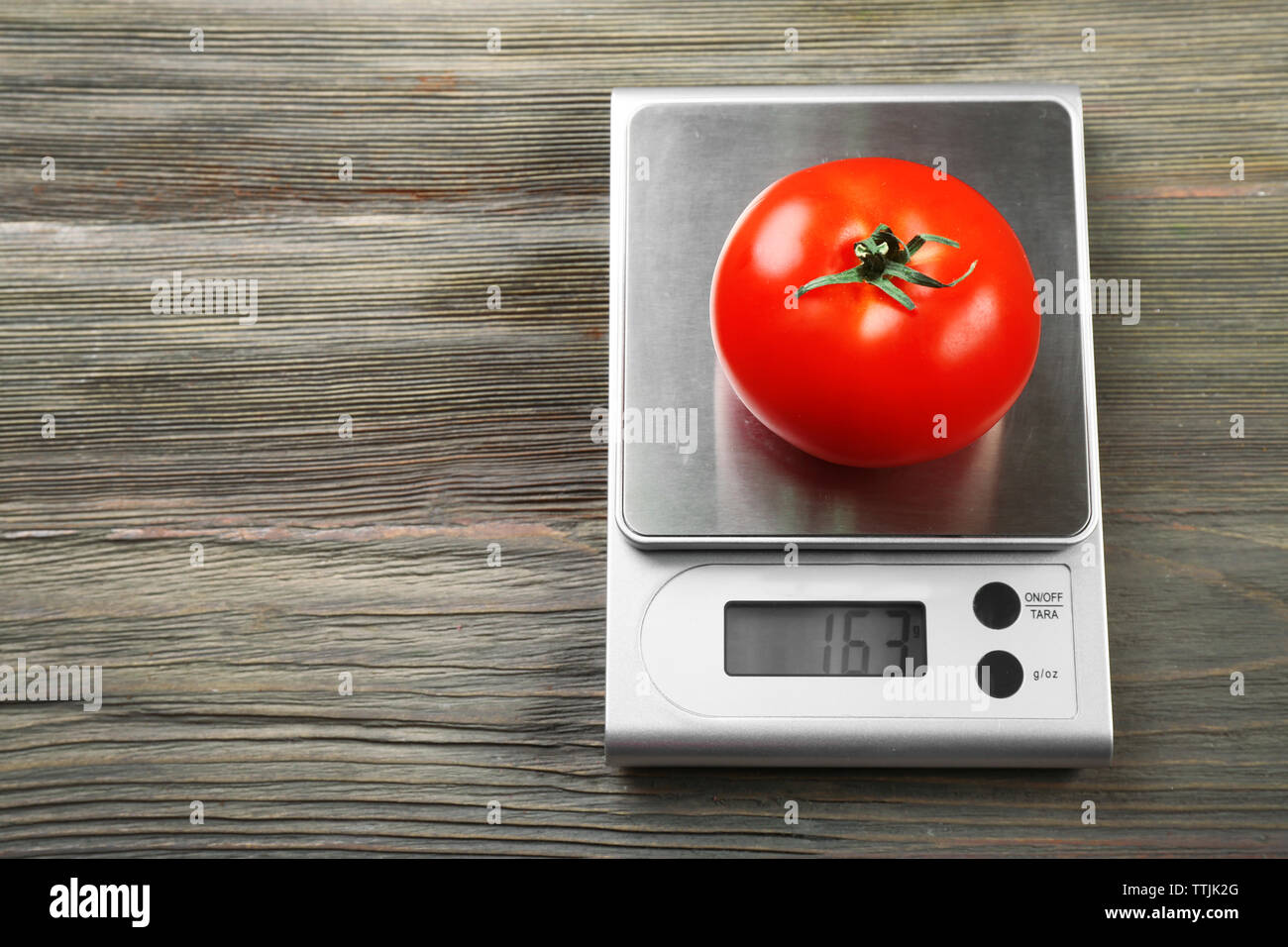 Tomato with digital kitchen scales on wooden background Stock Photo - Alamy
