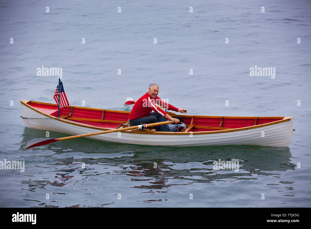 Happy senior man rowing boat in lake Stock Photo - Alamy