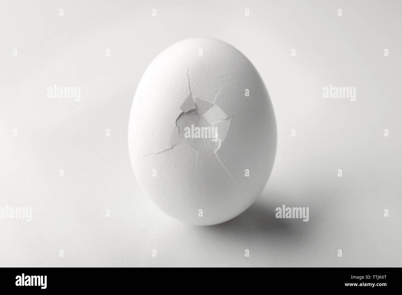 Cracked egg on white background Stock Photo - Alamy