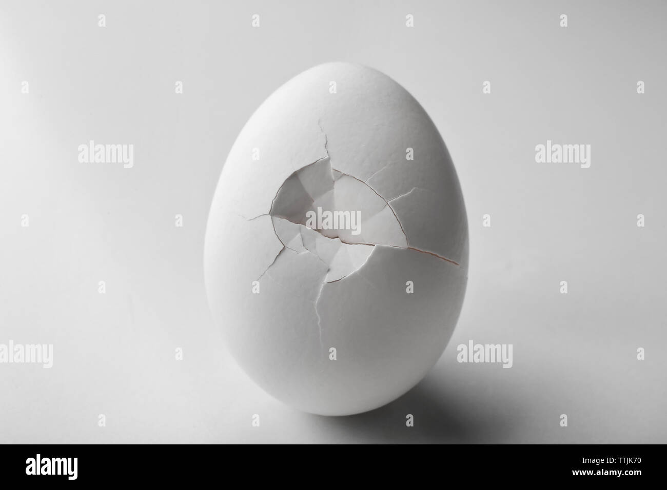 Cracked egg on white background Stock Photo - Alamy