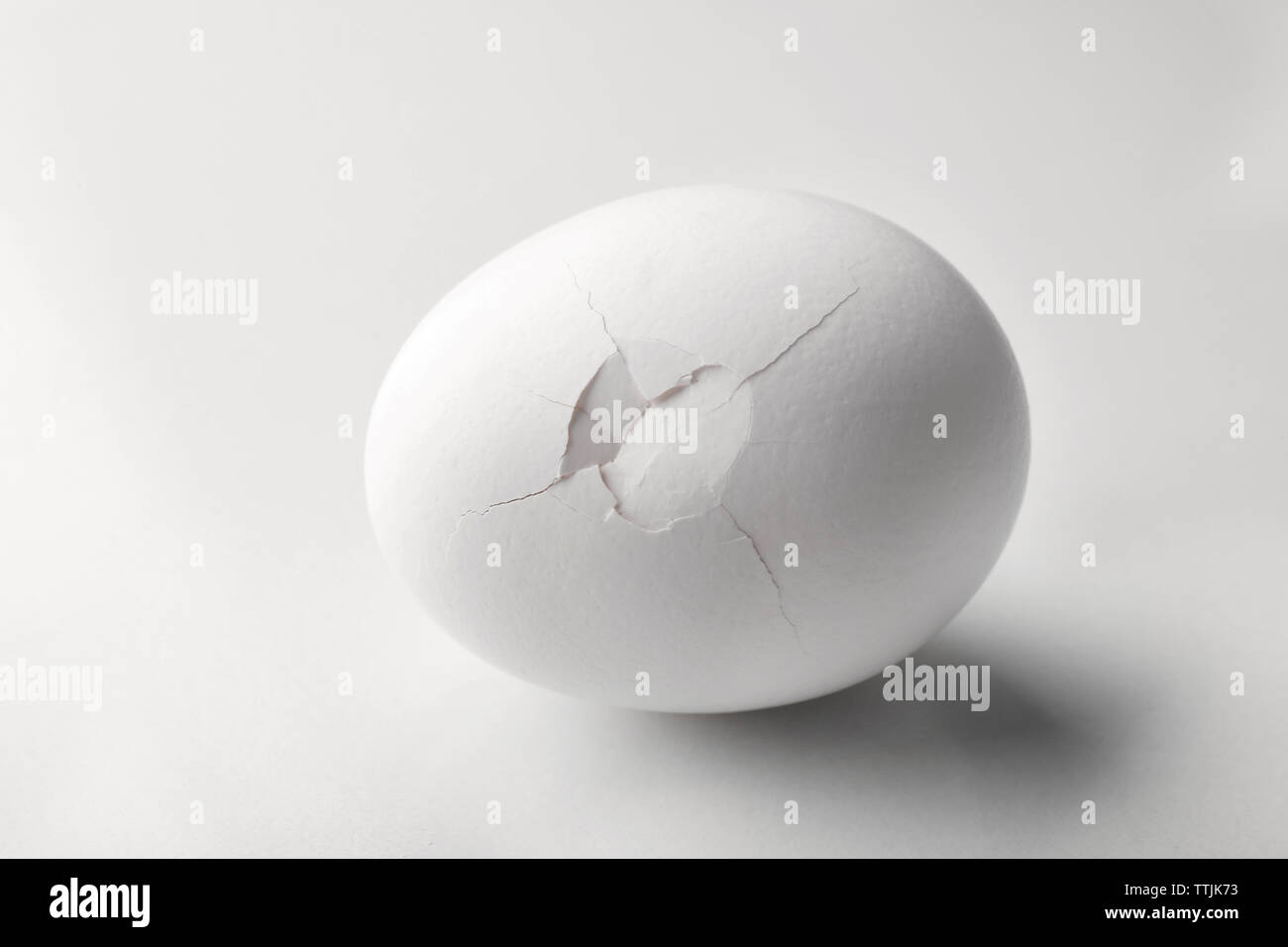 Cracked egg on white background Stock Photo - Alamy