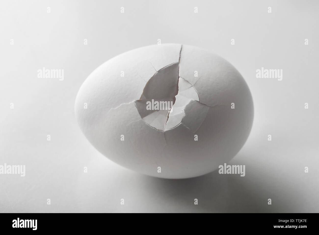 Cracked egg on white background Stock Photo - Alamy