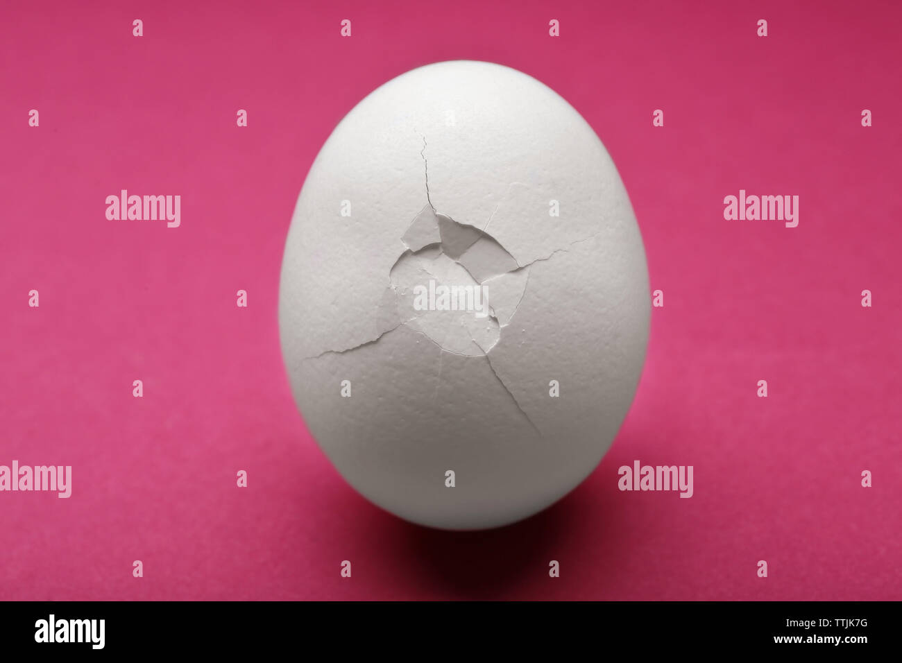 Cracked egg on pink background Stock Photo - Alamy