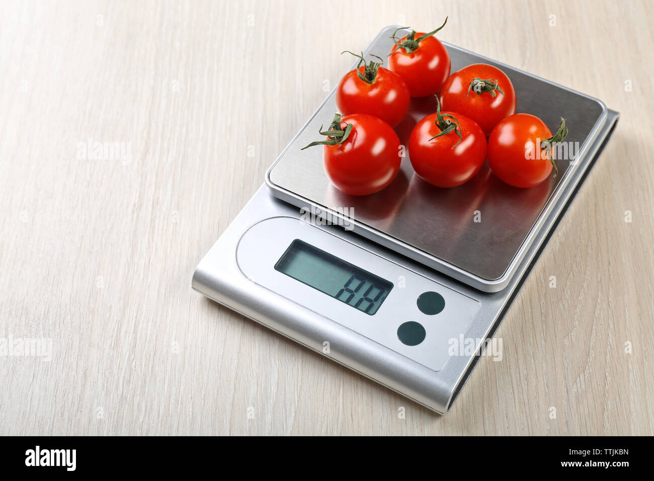 Tomatoes with digital kitchen scales on wooden background Stock Photo ...