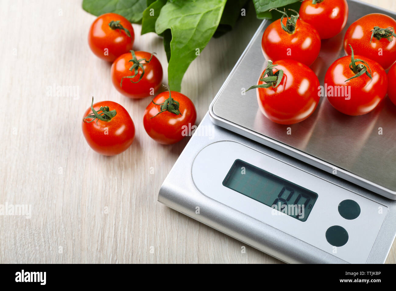 Tomatoes with digital kitchen scales on wooden background Stock Photo ...