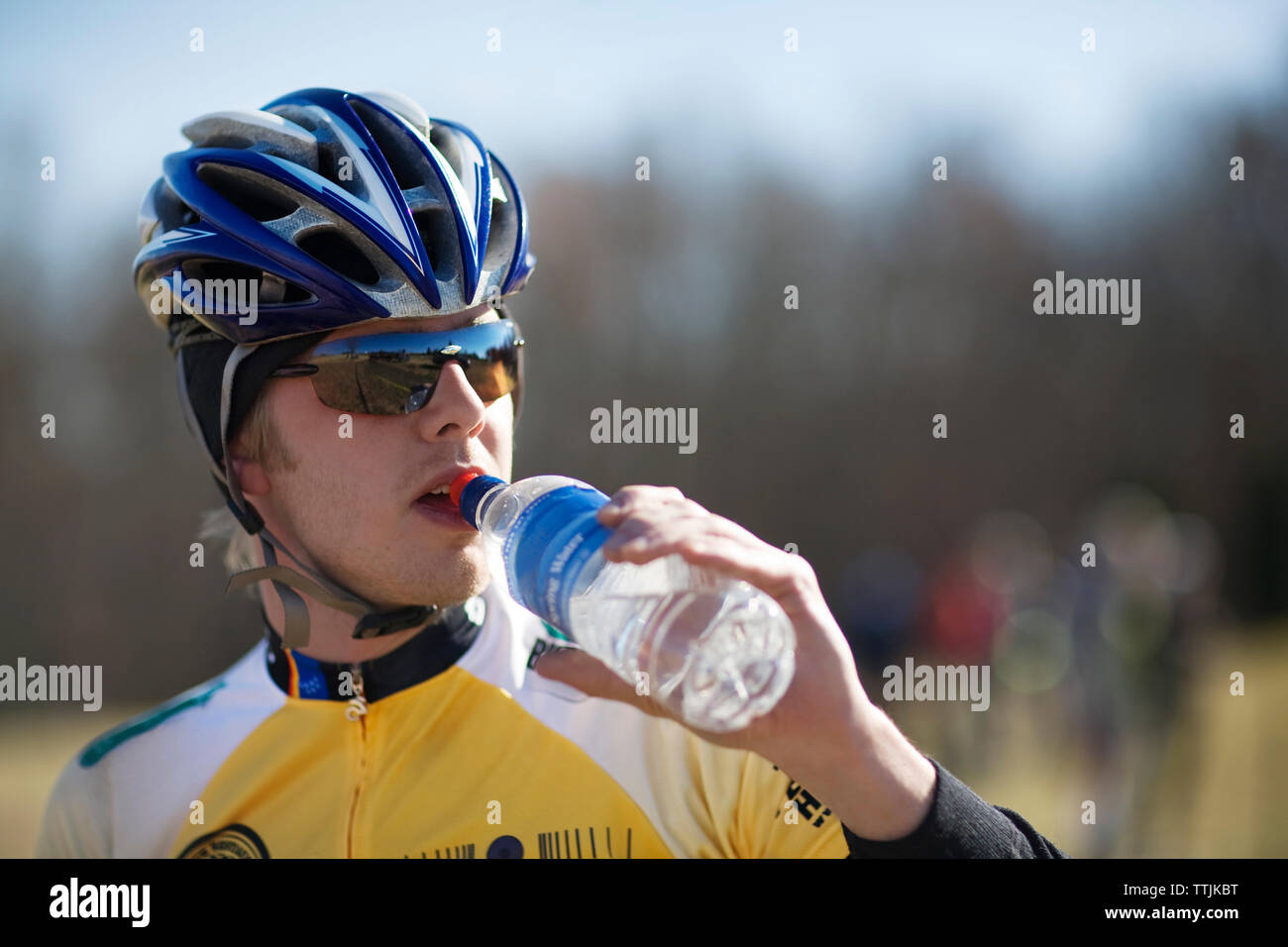 Cyclist drinking water while standing Stock Photo - Alamy
