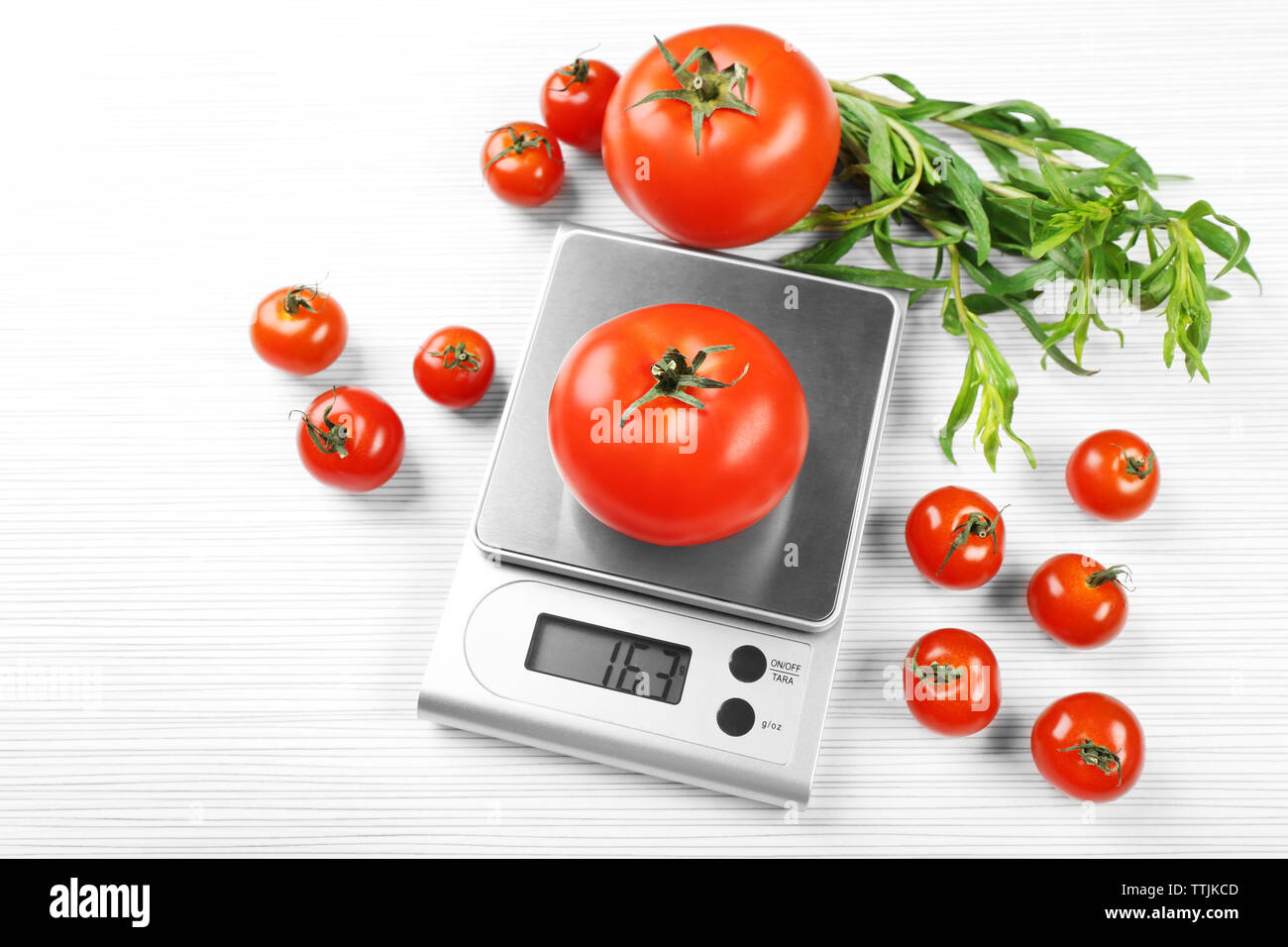 Tomatoes with digital kitchen scales on wooden background Stock Photo ...