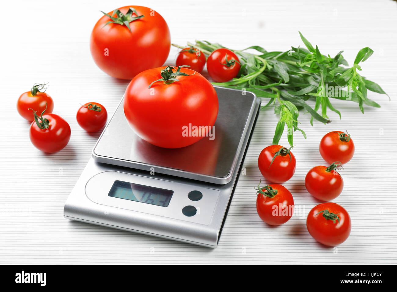 Tomatoes with digital kitchen scales on wooden background Stock Photo ...
