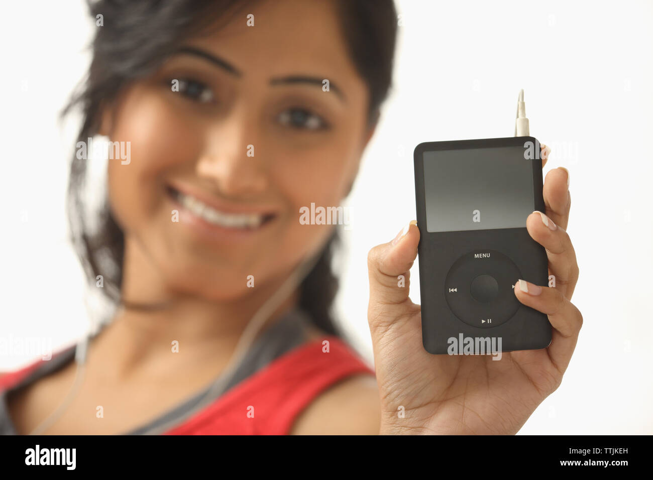 Indian woman listening to Mp3 player Stock Photo - Alamy