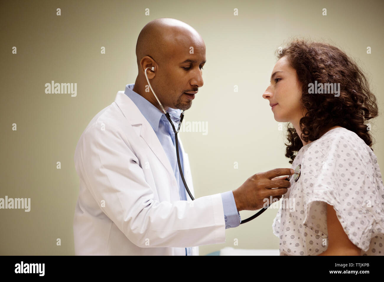 Side view of doctor examining patient in hospital Stock Photo - Alamy