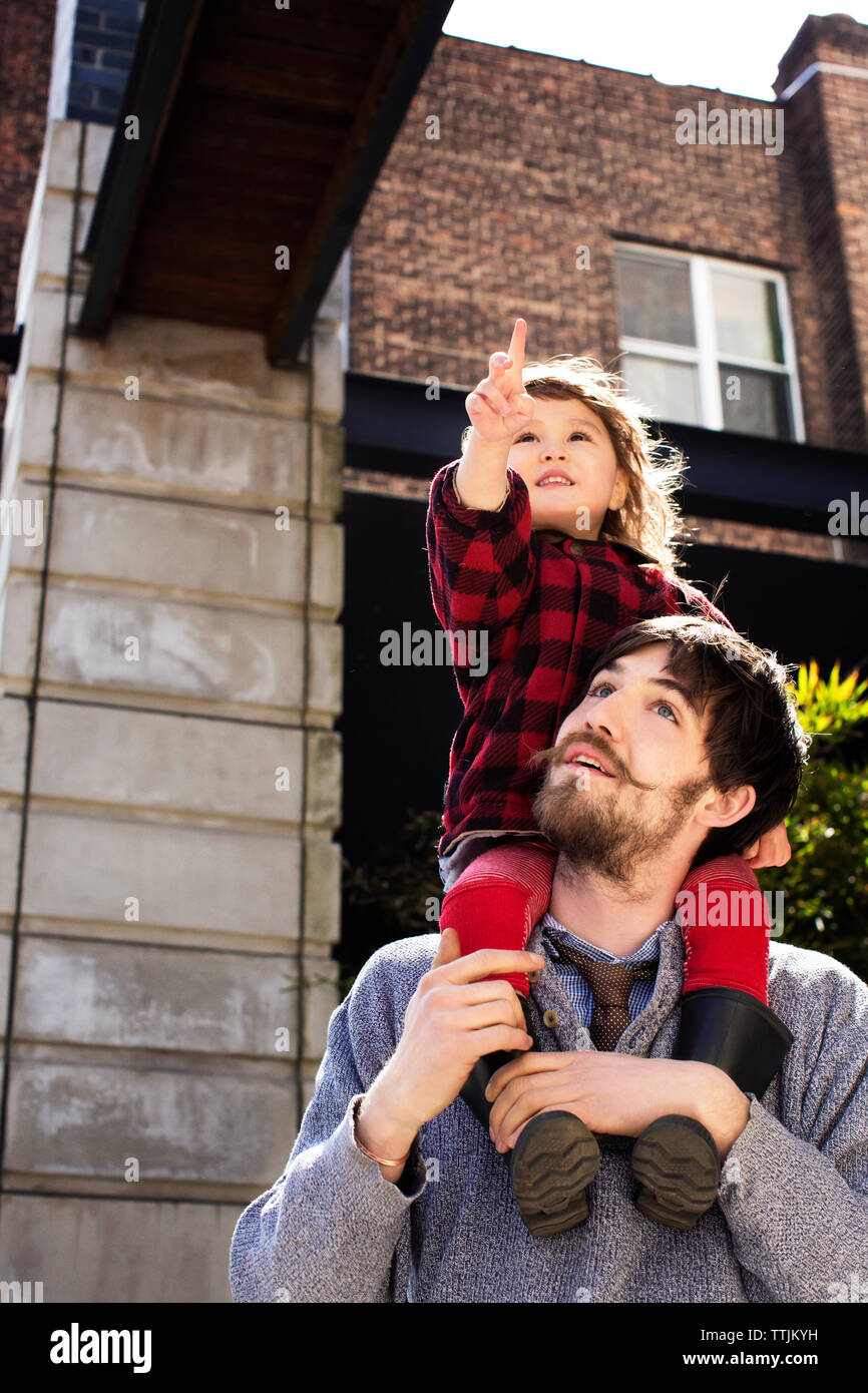 Father looking away while carrying daughter at backyard Stock Photo - Alamy