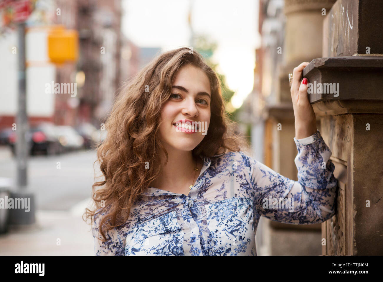 Woman standing by wall hi-res stock photography and images - Alamy