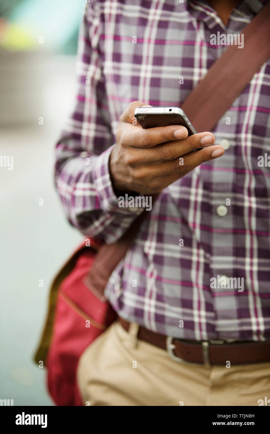 Midsection of man using smart phone Stock Photo - Alamy