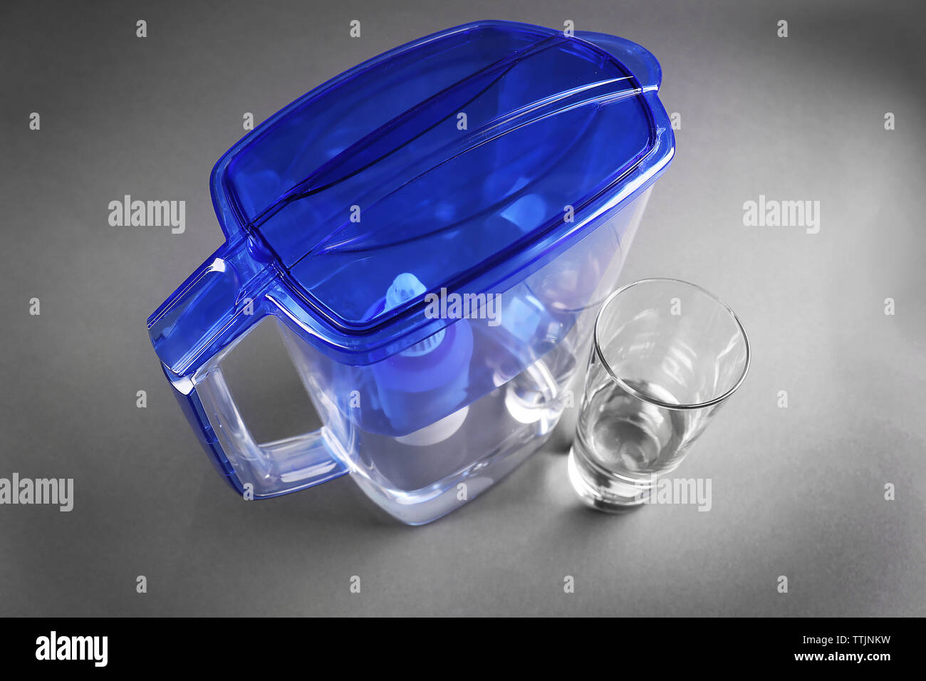 Blue water filter with glass on grey background Stock Photo - Alamy