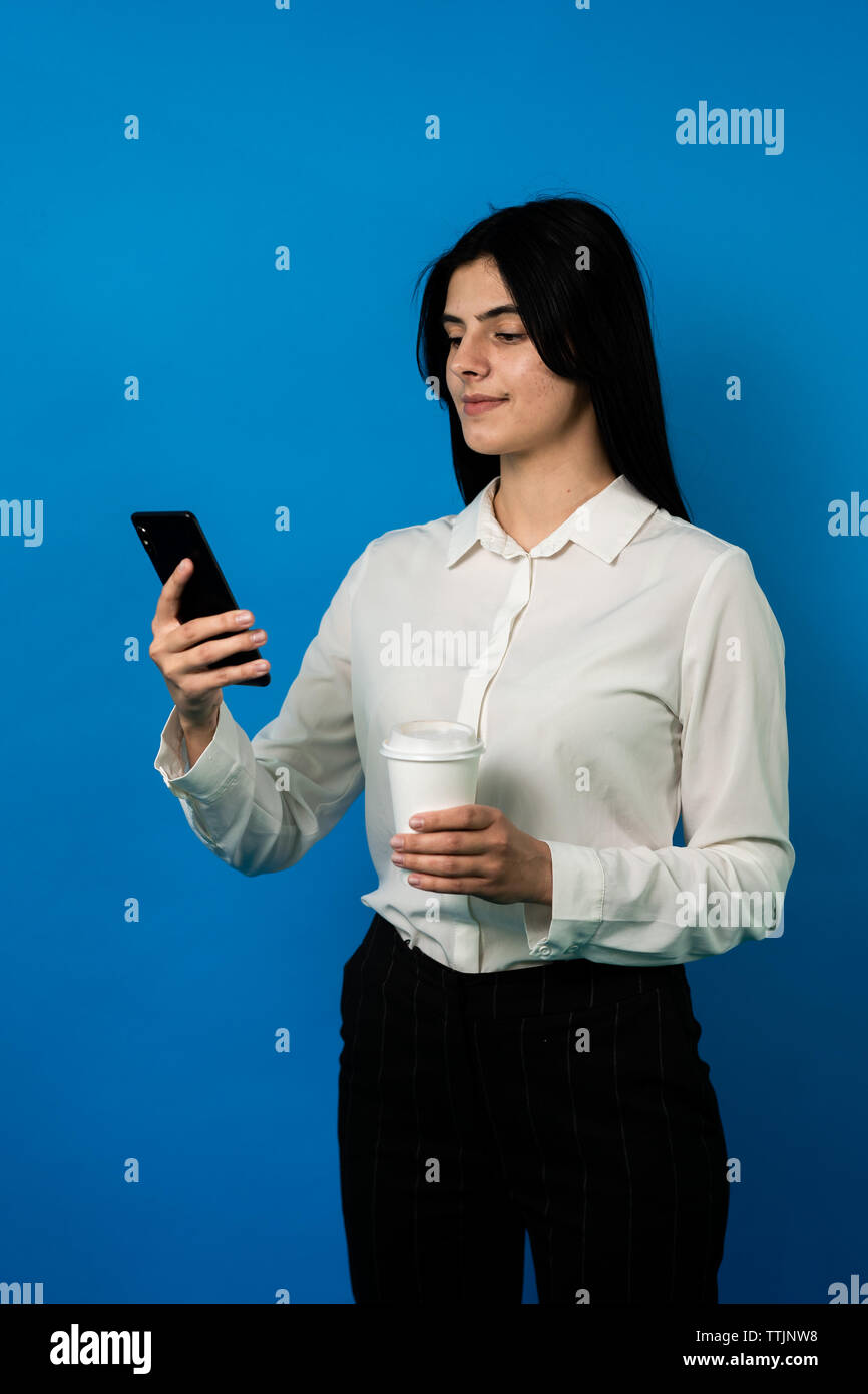 business woman with smartphone, look at phone, serious. vertical photo ...