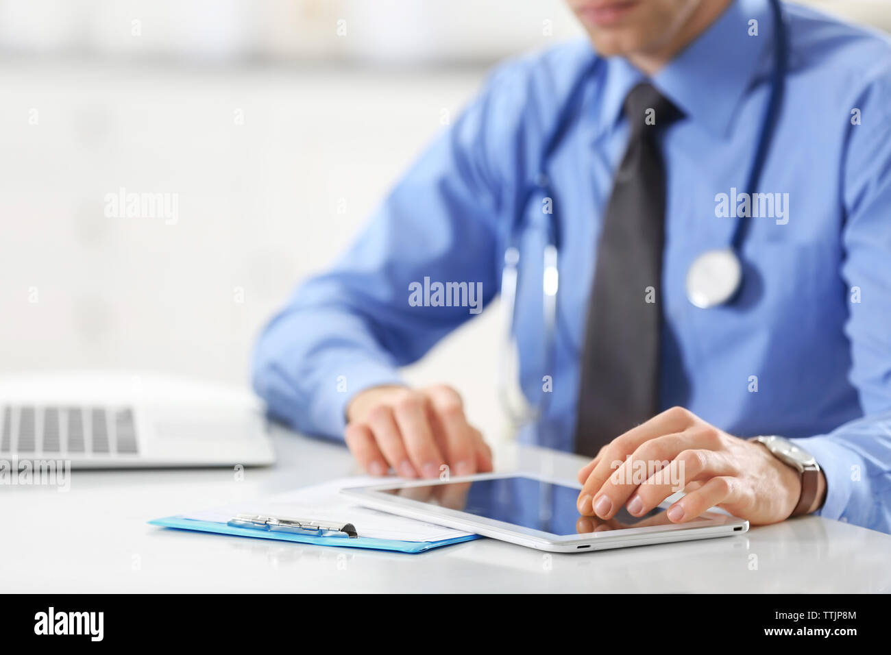 Doctor using tablet for work in hospital Stock Photo - Alamy