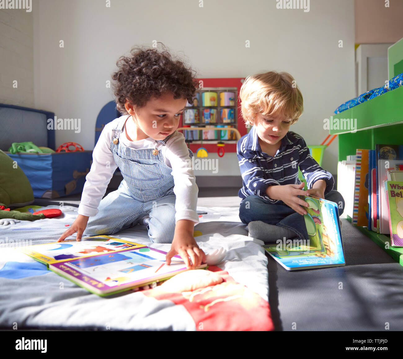 Children with picture books in kindergarten on sunny day Stock Photo ...