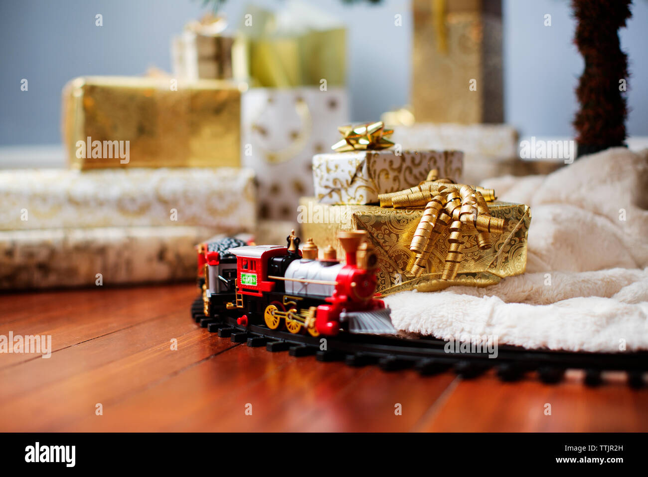 Miniature train and gift boxes on hardwood floor Stock Photo - Alamy