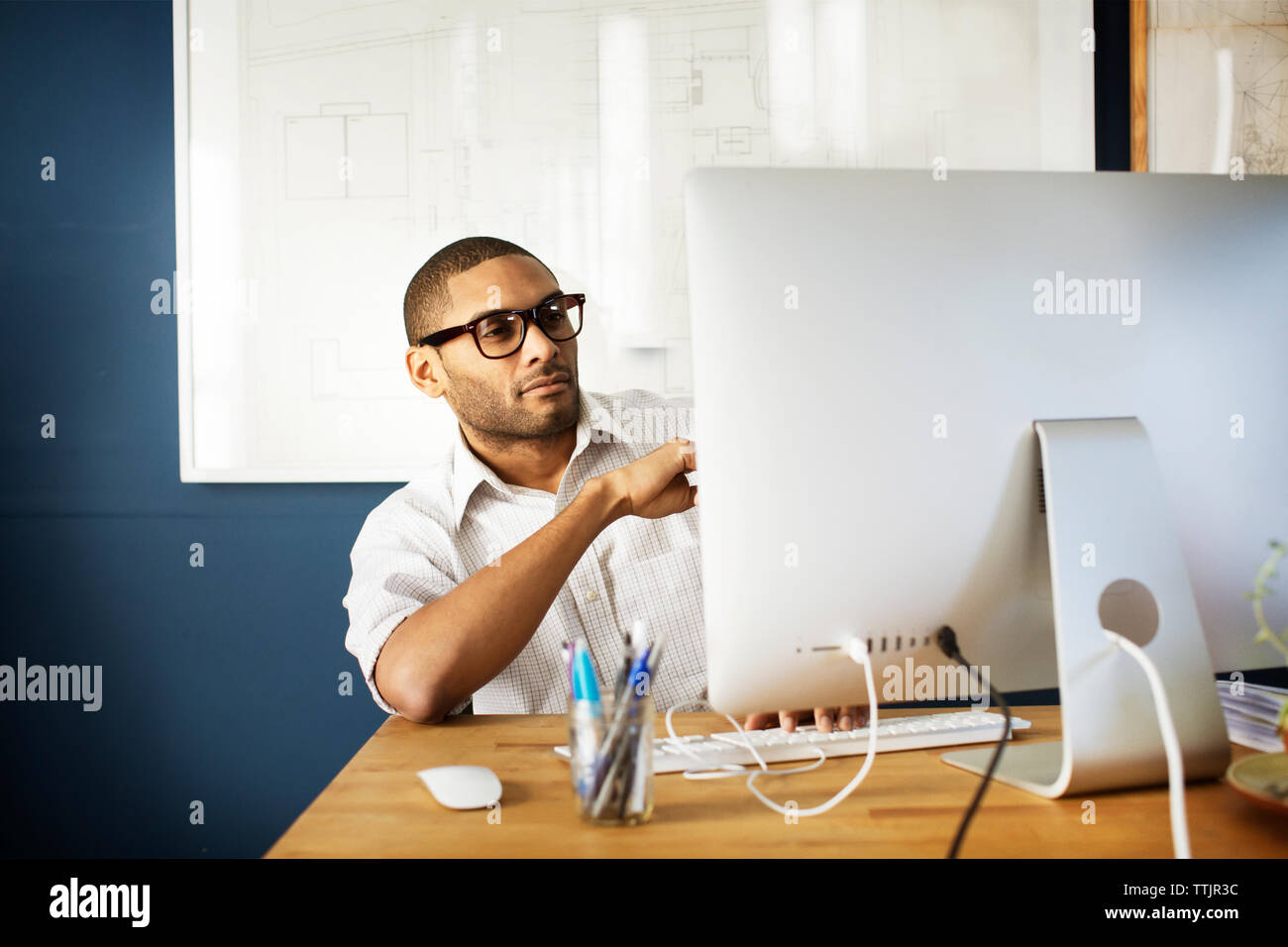 Man working on desktop computer in office Stock Photo - Alamy