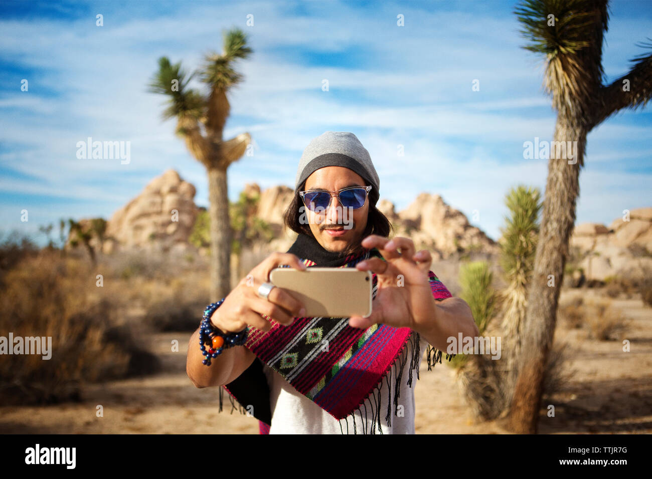 Man taking selfie while standing in desert area Stock Photo - Alamy