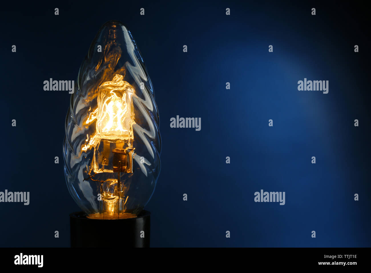 Illuminated light bulb on dark blue background Stock Photo - Alamy