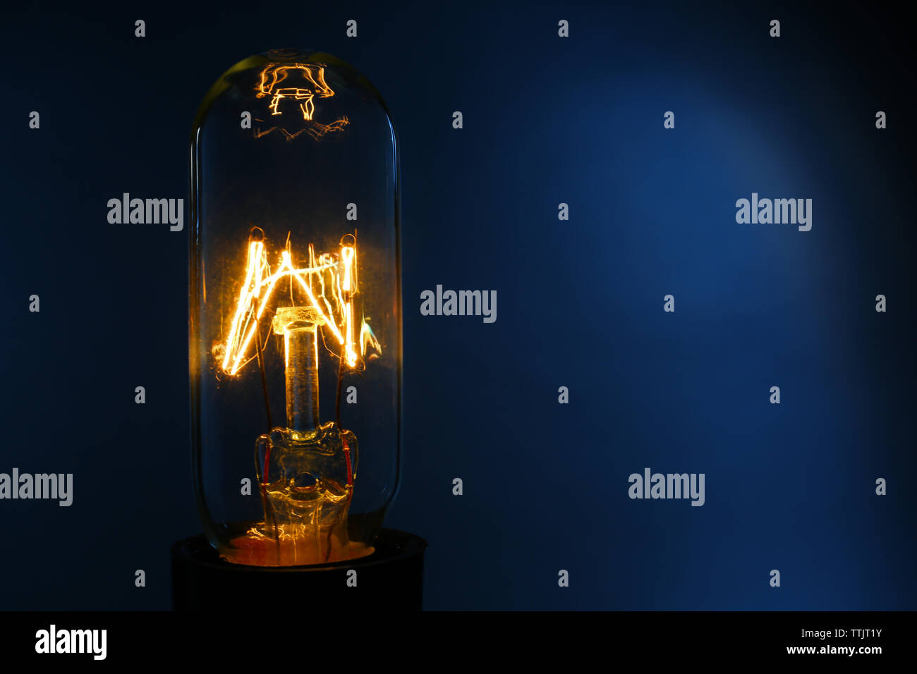 Illuminated light bulb on dark blue background Stock Photo - Alamy