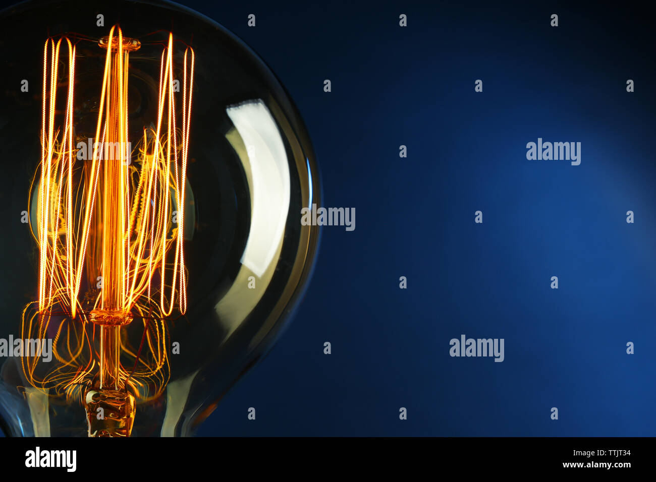 Illuminated light bulb on dark blue background Stock Photo - Alamy