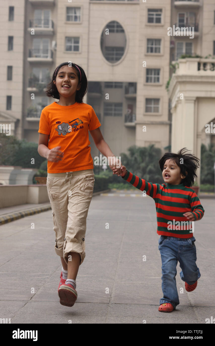 Two girls running in front of a building Stock Photo - Alamy
