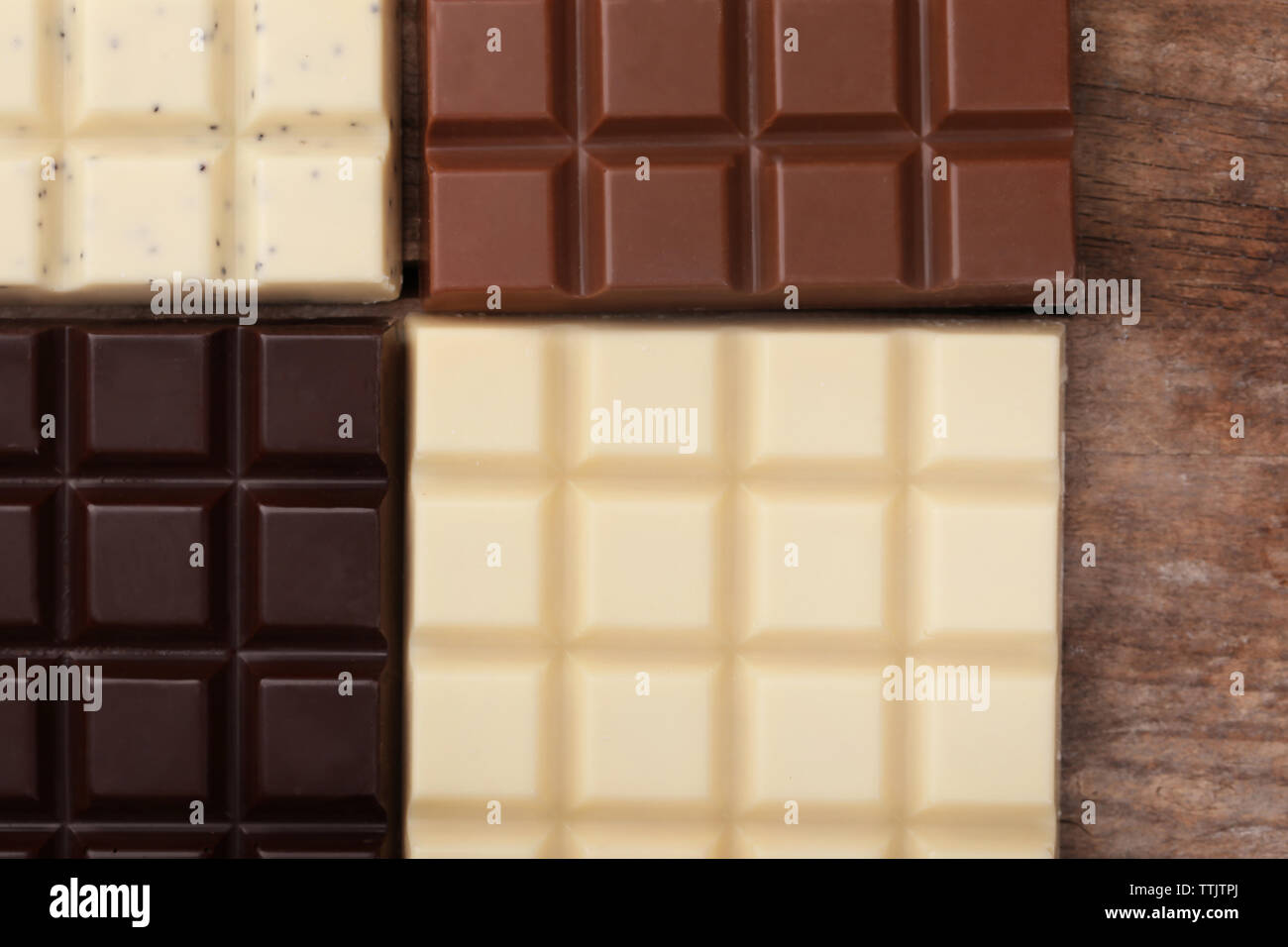 Different chocolate bars on wooden background Stock Photo - Alamy