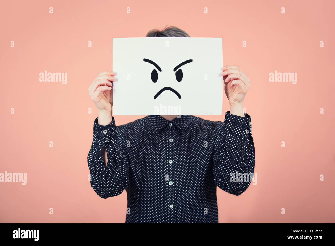 Businesswoman covering face using a white paper sheet with angry sad ...