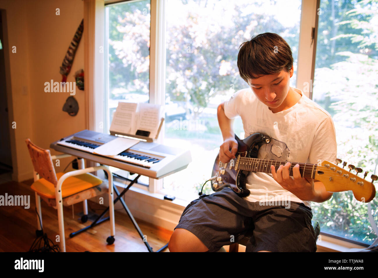 Teenager practicing electric guitar at home Stock Photo - Alamy