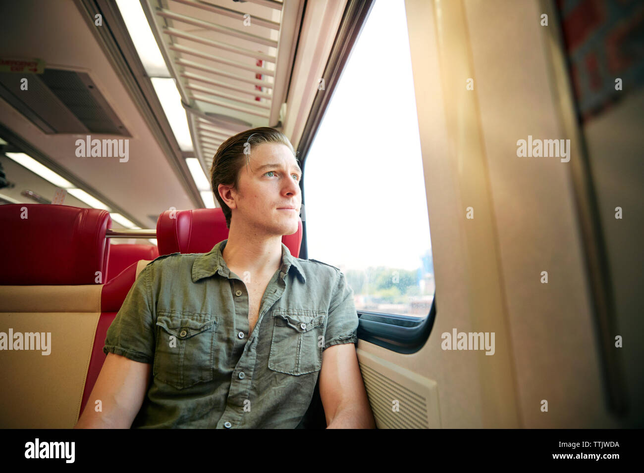 Man looking through window while traveling in train Stock Photo - Alamy