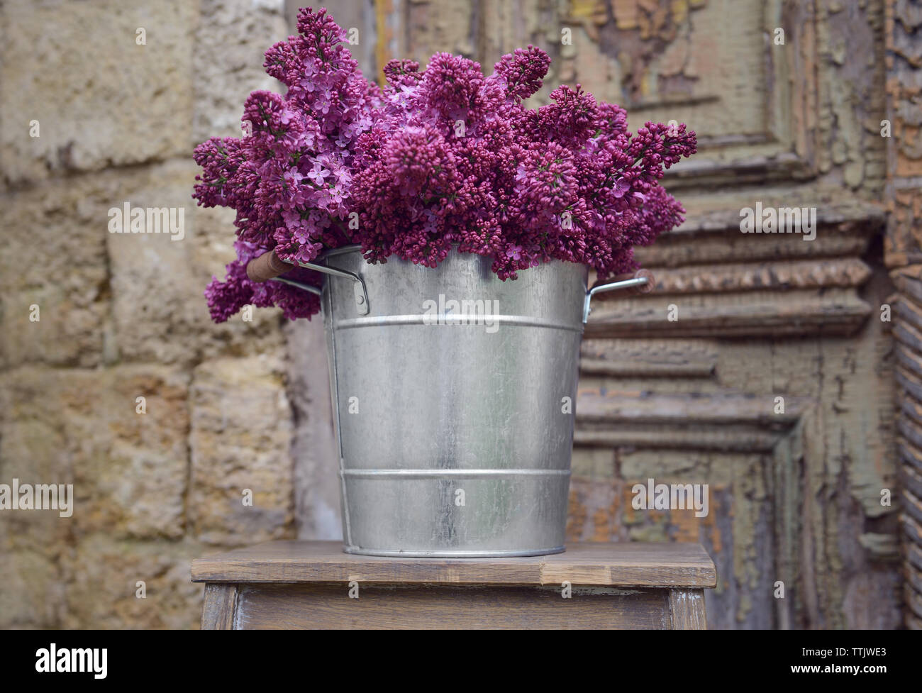 Purple lilac in metal bucket on porch Stock Photo - Alamy