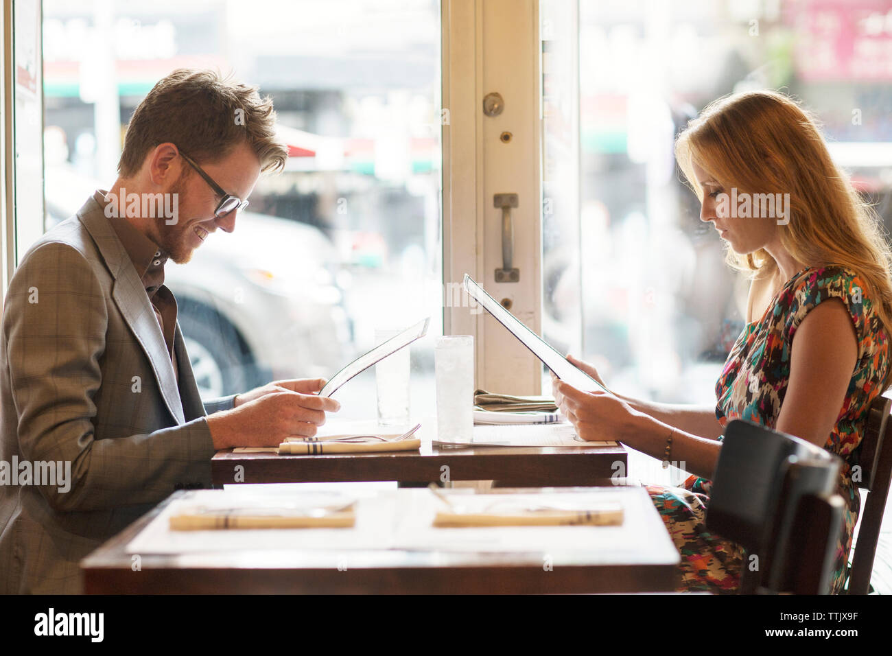 Side view of couple reading menu while sitting in restaurant Stock ...