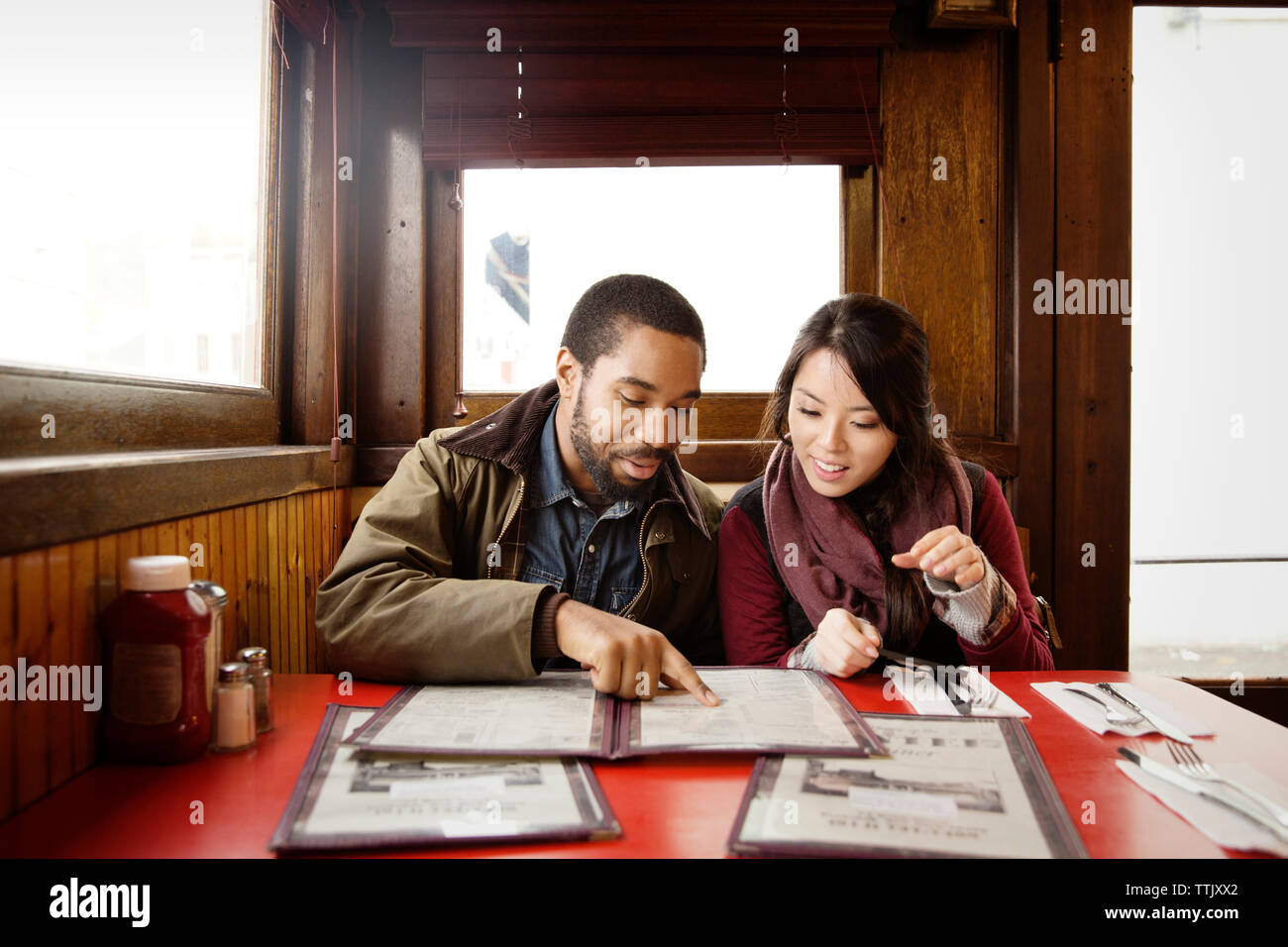 Couple looking at menu while sitting in restaurant Stock Photo - Alamy