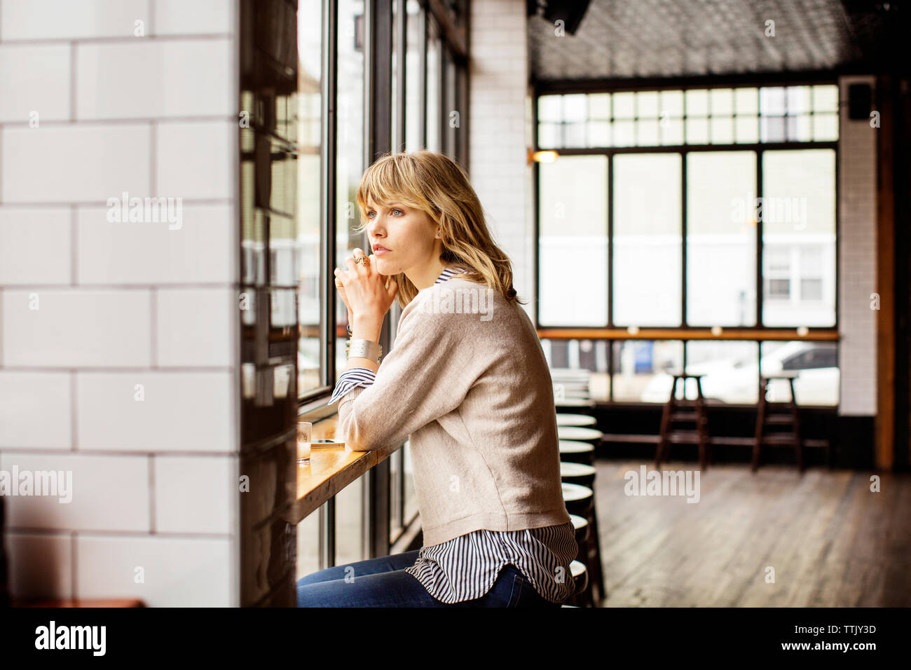 Blond woman sitting at bar hi-res stock photography and images - Alamy