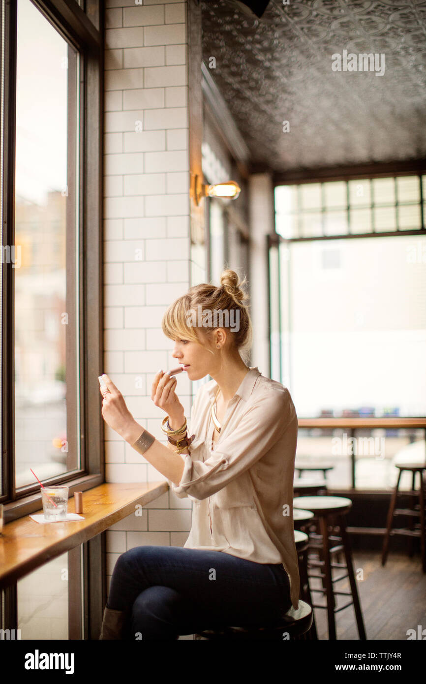 Woman sitting on bar stool hi-res stock photography and images - Alamy