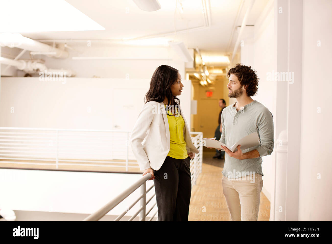business people talking while standing in corridor Stock Photo - Alamy