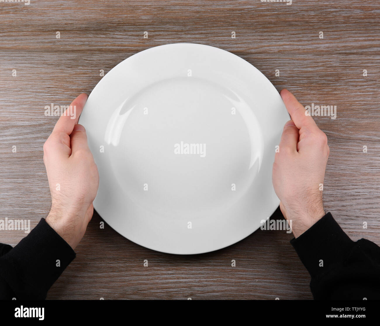 Man holding empty plate. Hunger concept Stock Photo - Alamy