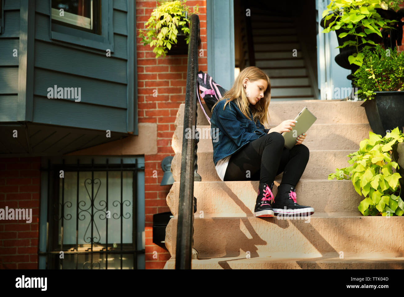 Girl sitting on steps hi-res stock photography and images - Alamy