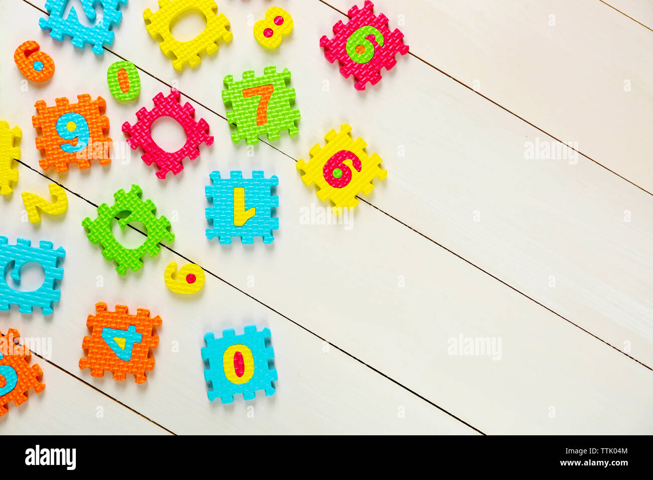 Colorful puzzle mat on wooden background Stock Photo - Alamy
