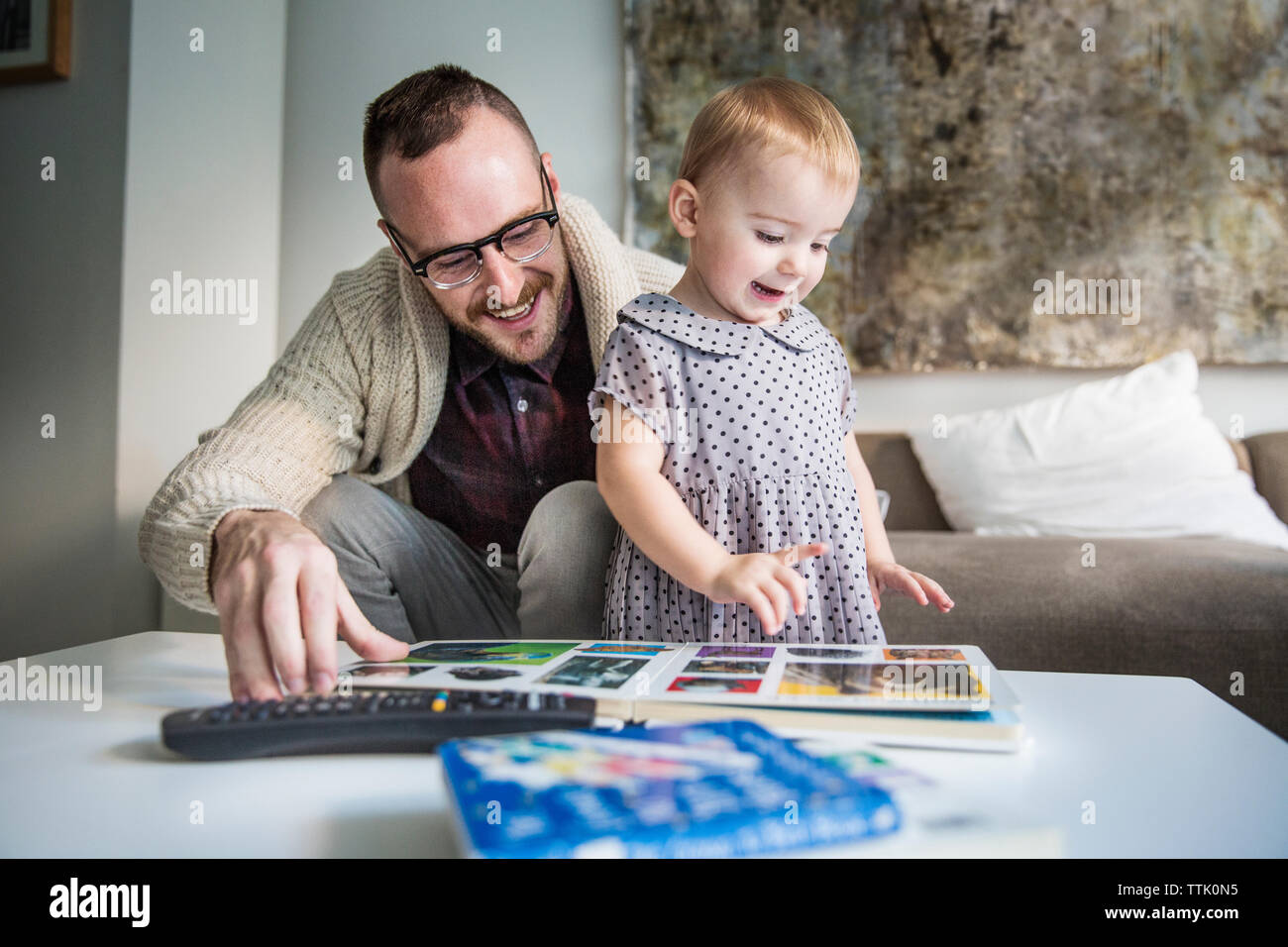 Happy father reading picture book to daughter at home Stock Photo - Alamy