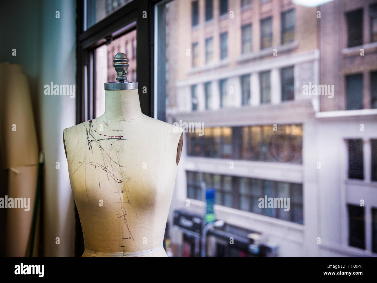 Dressmaker's model by glass window at design studio Stock Photo - Alamy